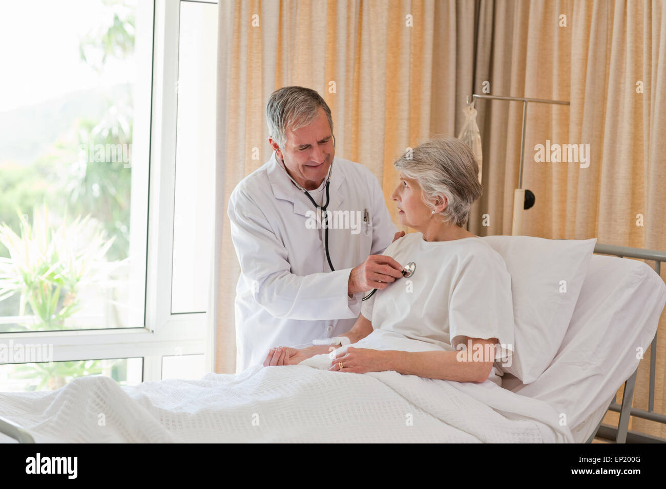 Senior doctor taking the heartbeat of his patient Stock Photo - Alamy