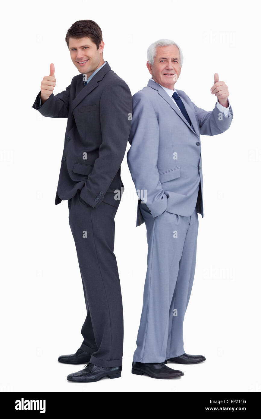 Businessmen standing back to back giving thumbs up Stock Photo - Alamy
