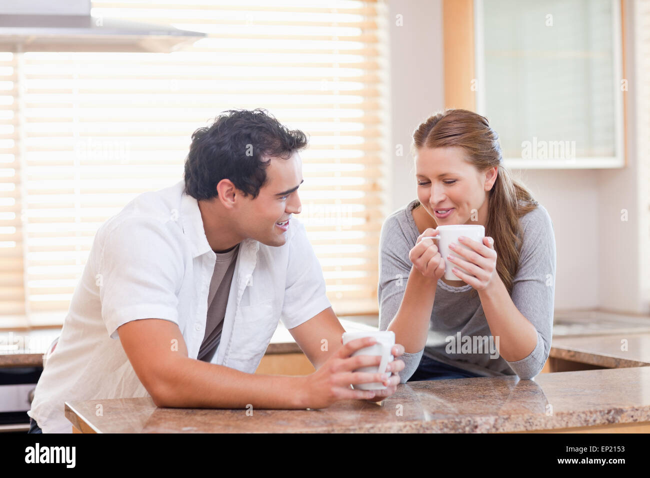 Couple enjoying tea in the kitchen Stock Photo - Alamy