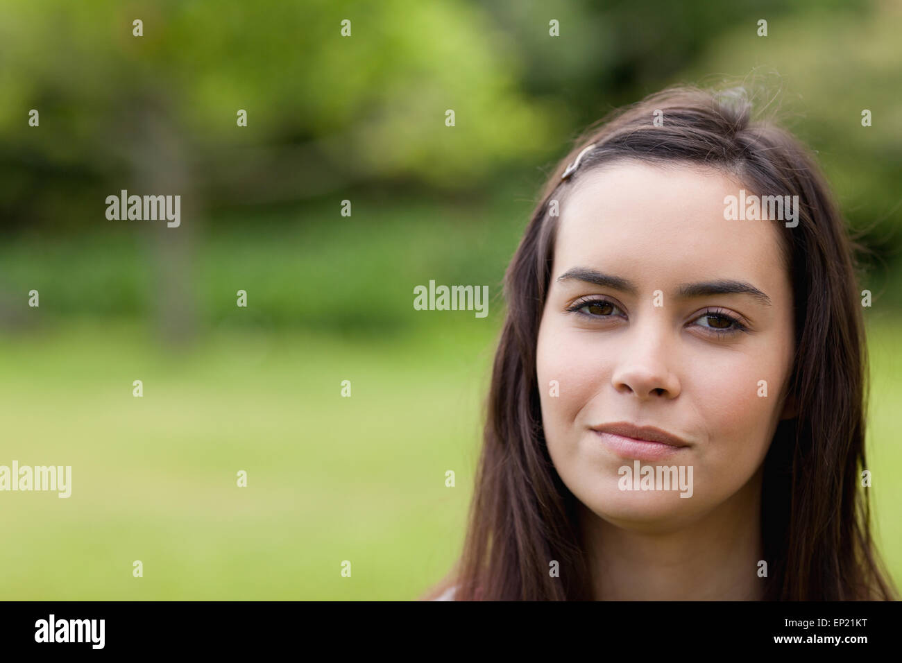 Young calm woman standing upright in a parkland Stock Photo - Alamy