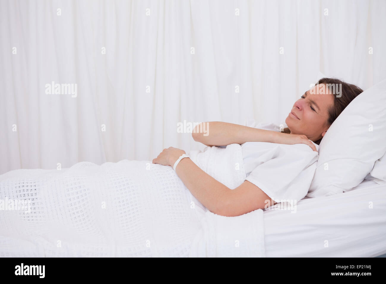 Side view of lying patient covering her shoulder Stock Photo - Alamy