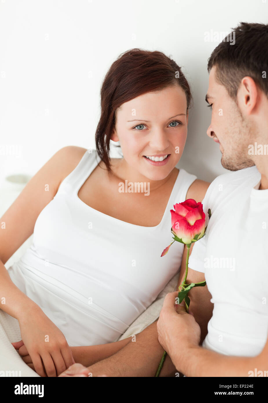 Close up of a Cheerful couple with a rose looking into camera Stock ...