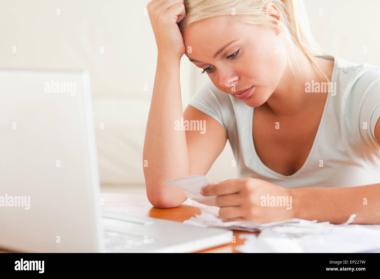 Stressed blond woman doing paperwork Stock Photo - Alamy