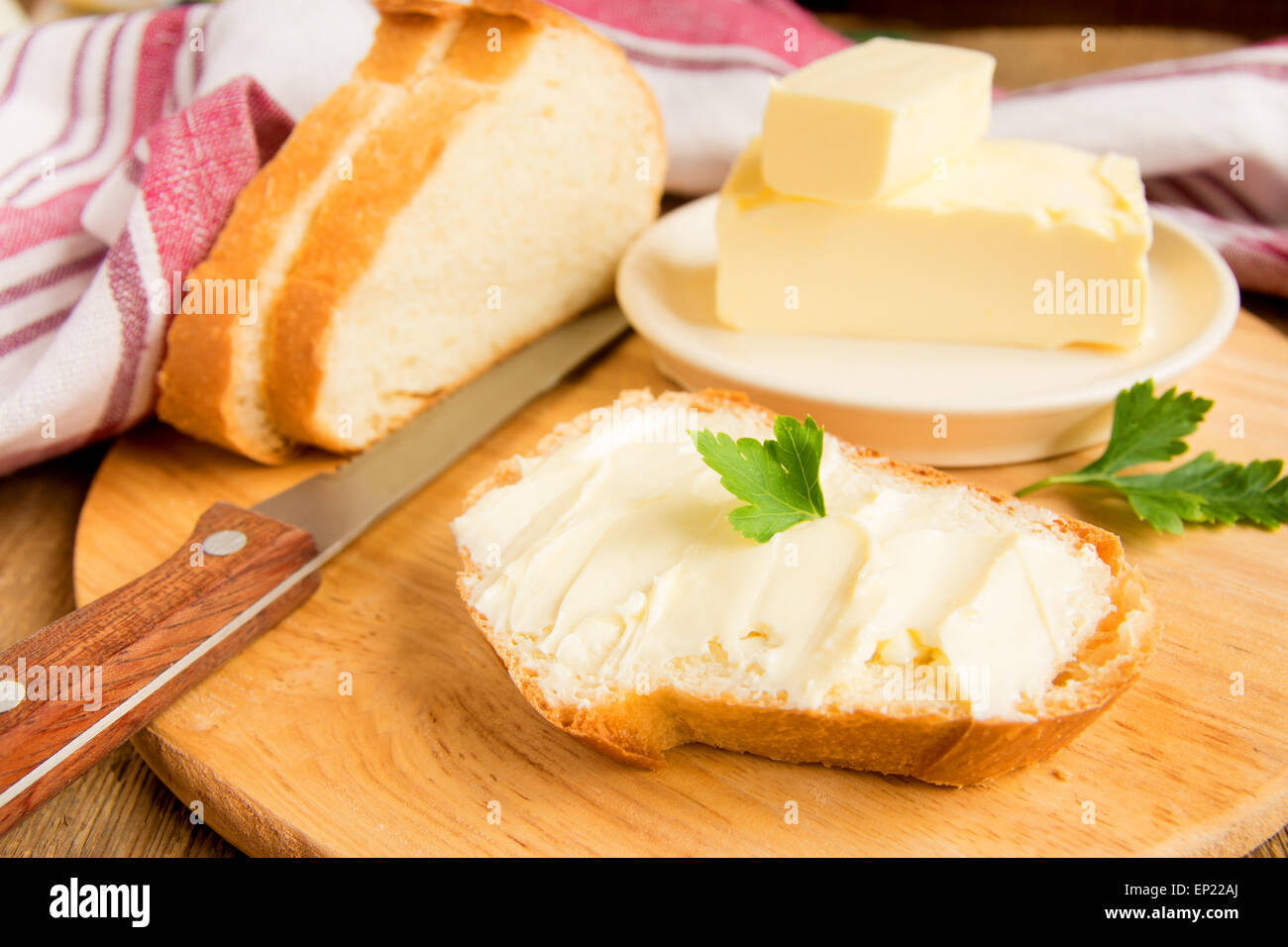 Butter and bread for breakfast, with parsley over wooden table Stock ...