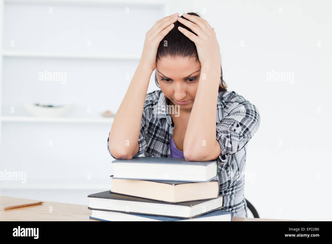 Depressed young student leaning on books Stock Photo - Alamy