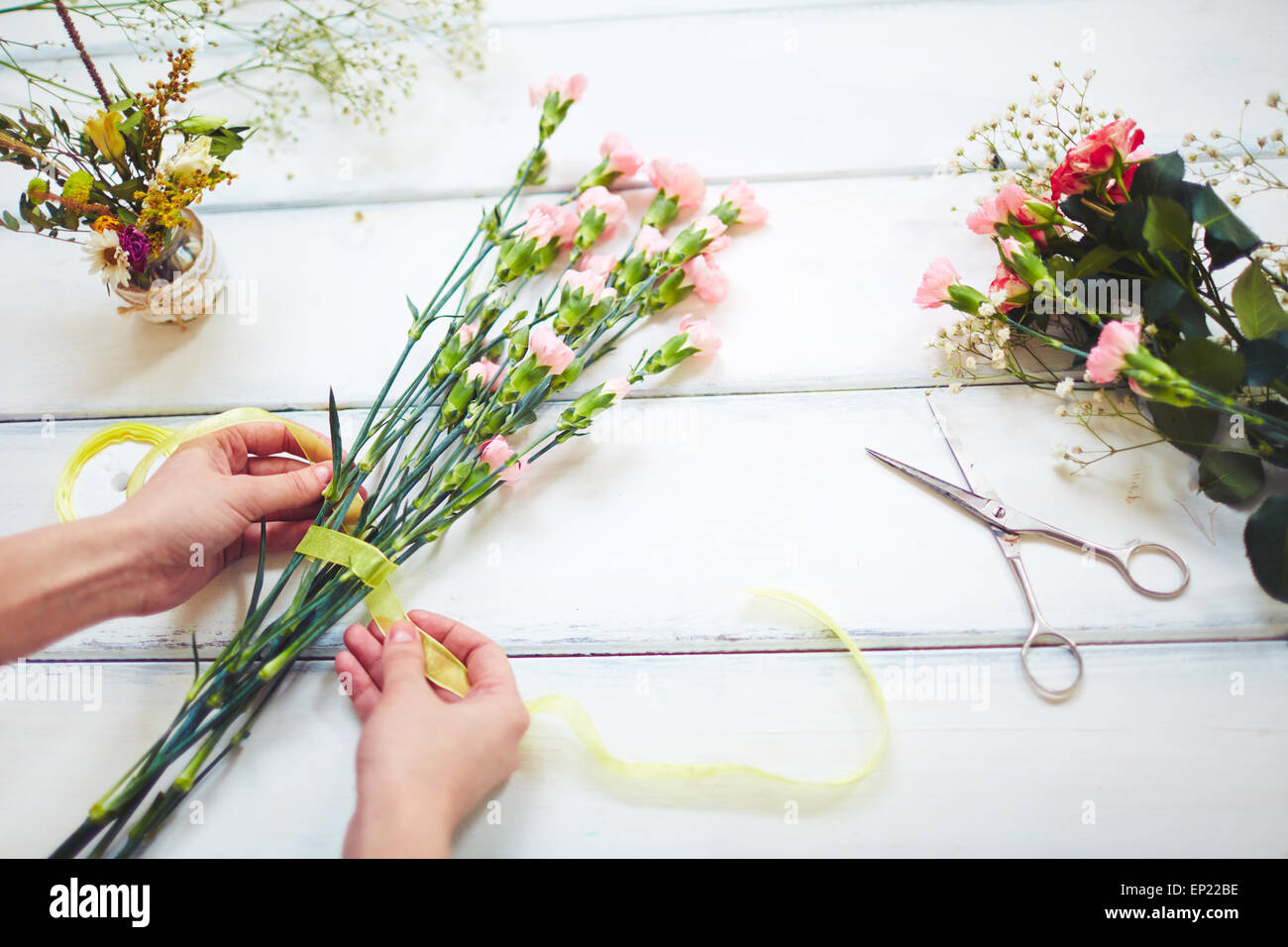 Female hands tying pink carnation bouquet Stock Photo - Alamy