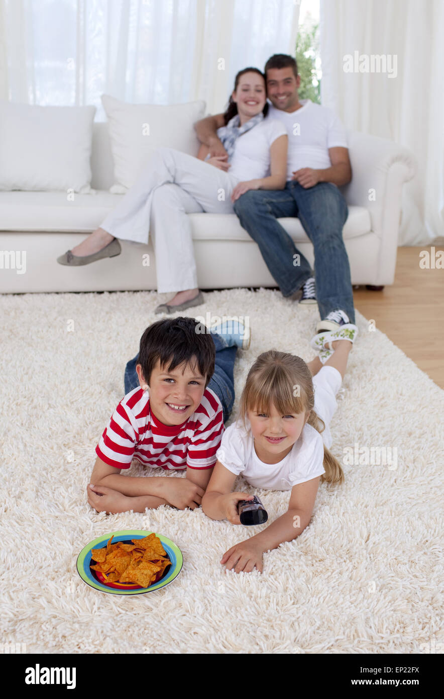 Happy children watching television on floor in living-room Stock Photo ...