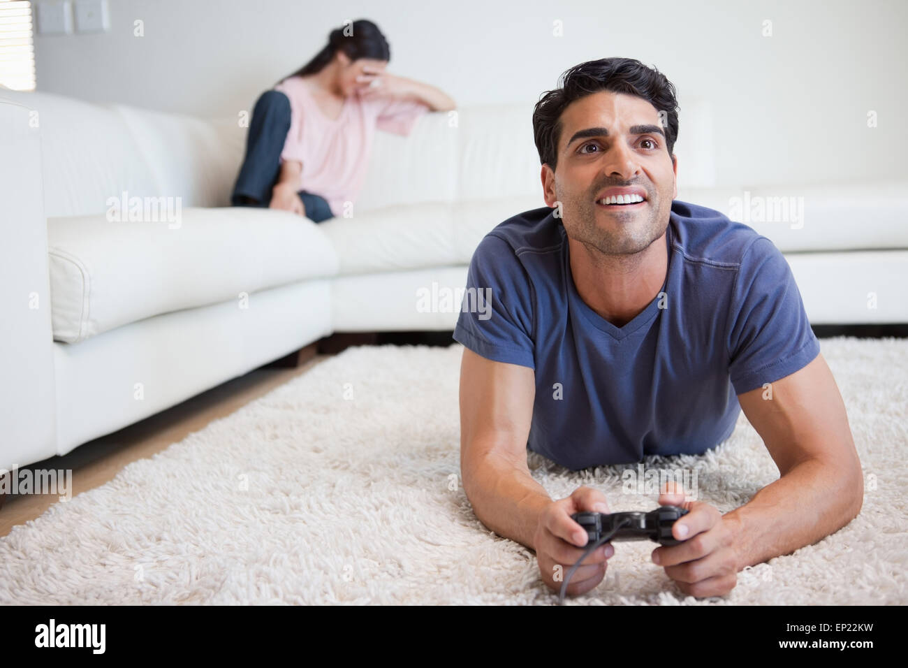 Man playing video games while his fiance is crying Stock Photo - Alamy