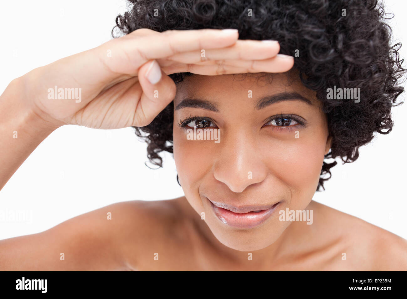 Smiling brunette precisely looking ahead with her hand above her eyes ...