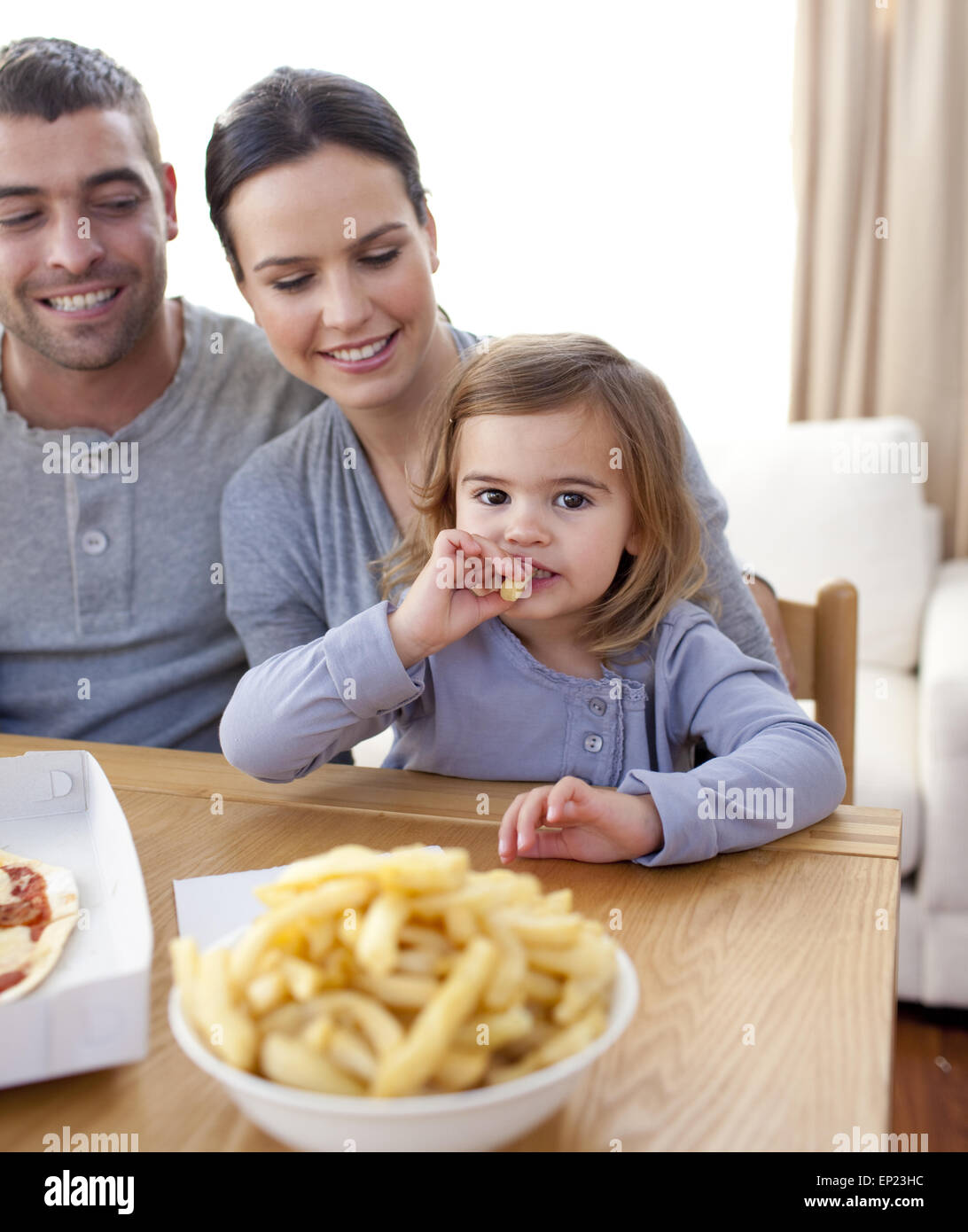 Little girl eating fries and pizza at home Stock Photo - Alamy