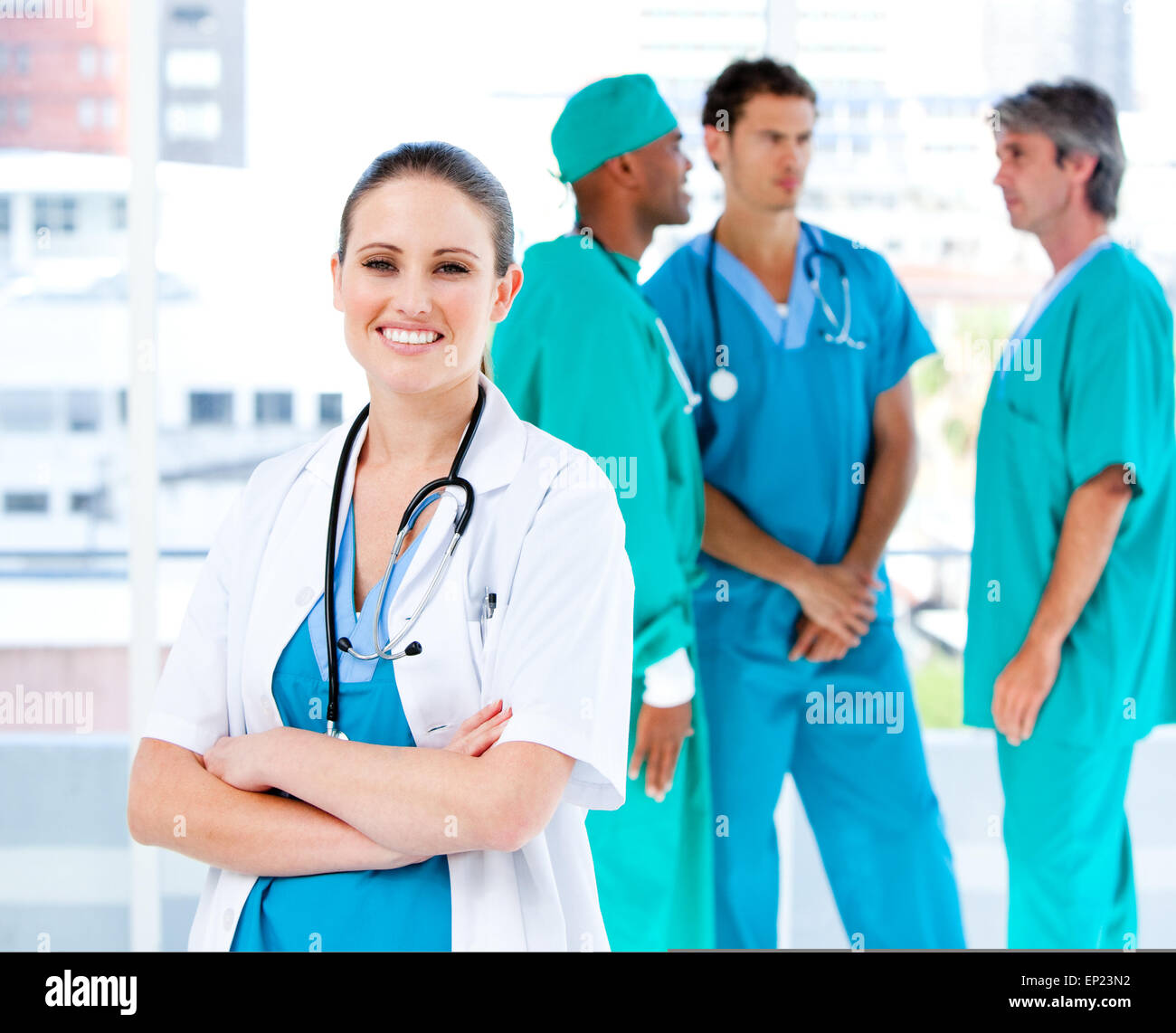 Radiant female doctor looking at the camera while her medical partners ...