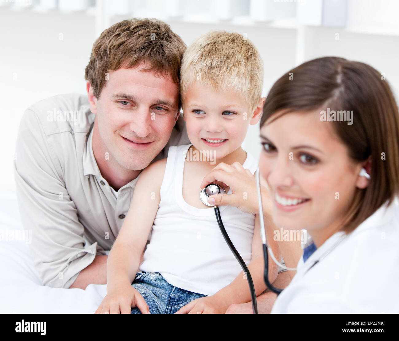 Portrait of beautiful female doctor examining a little boy with his ...