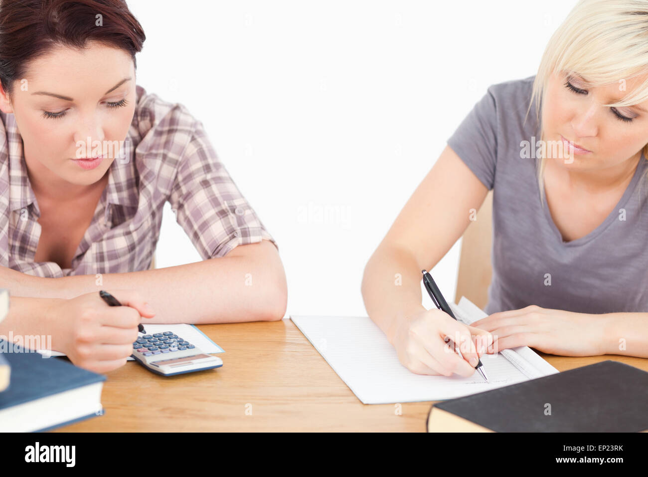 Pretty students learning at table Stock Photo - Alamy
