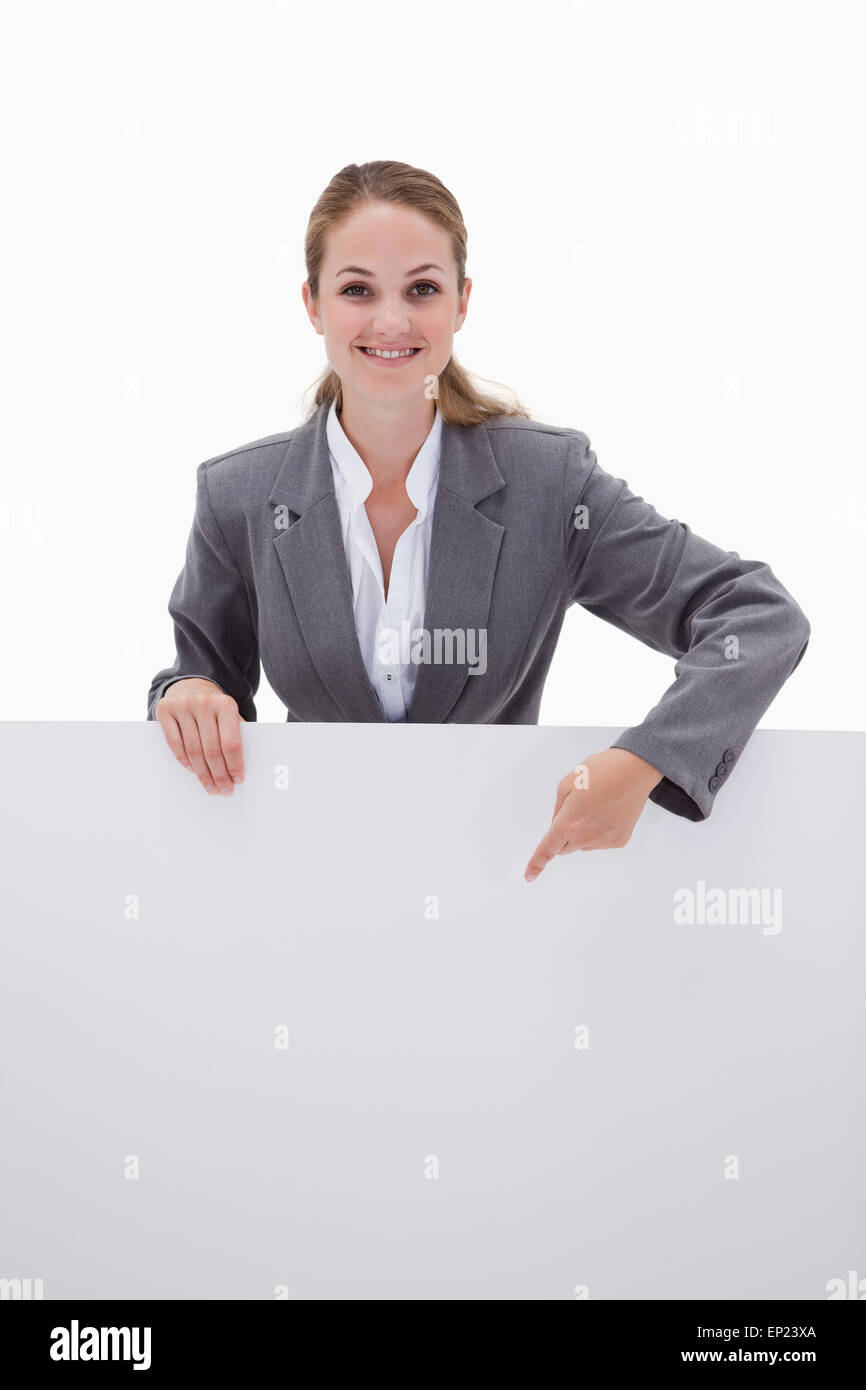 Smiling bank employee pointing down at blank sign Stock Photo - Alamy
