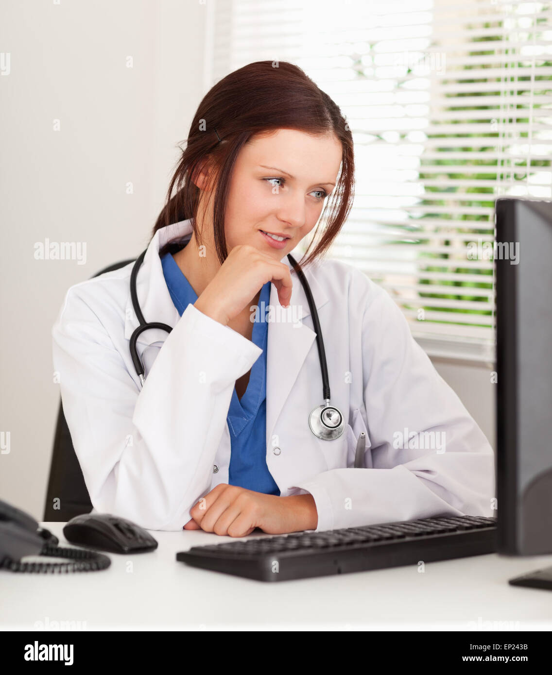Female doctor looking to pc screen Stock Photo - Alamy