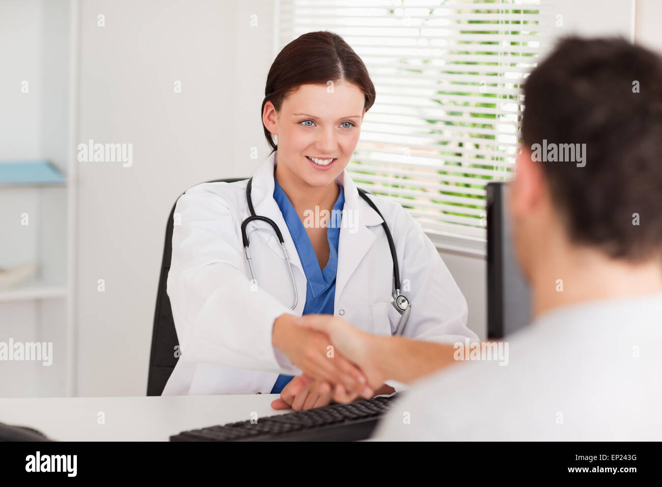 Female doctor greeting a patient Stock Photo - Alamy