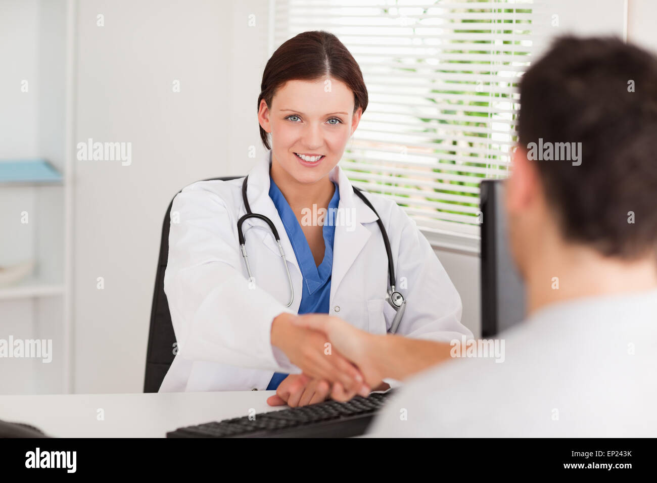 Female doctor hand shaking with patient Stock Photo - Alamy