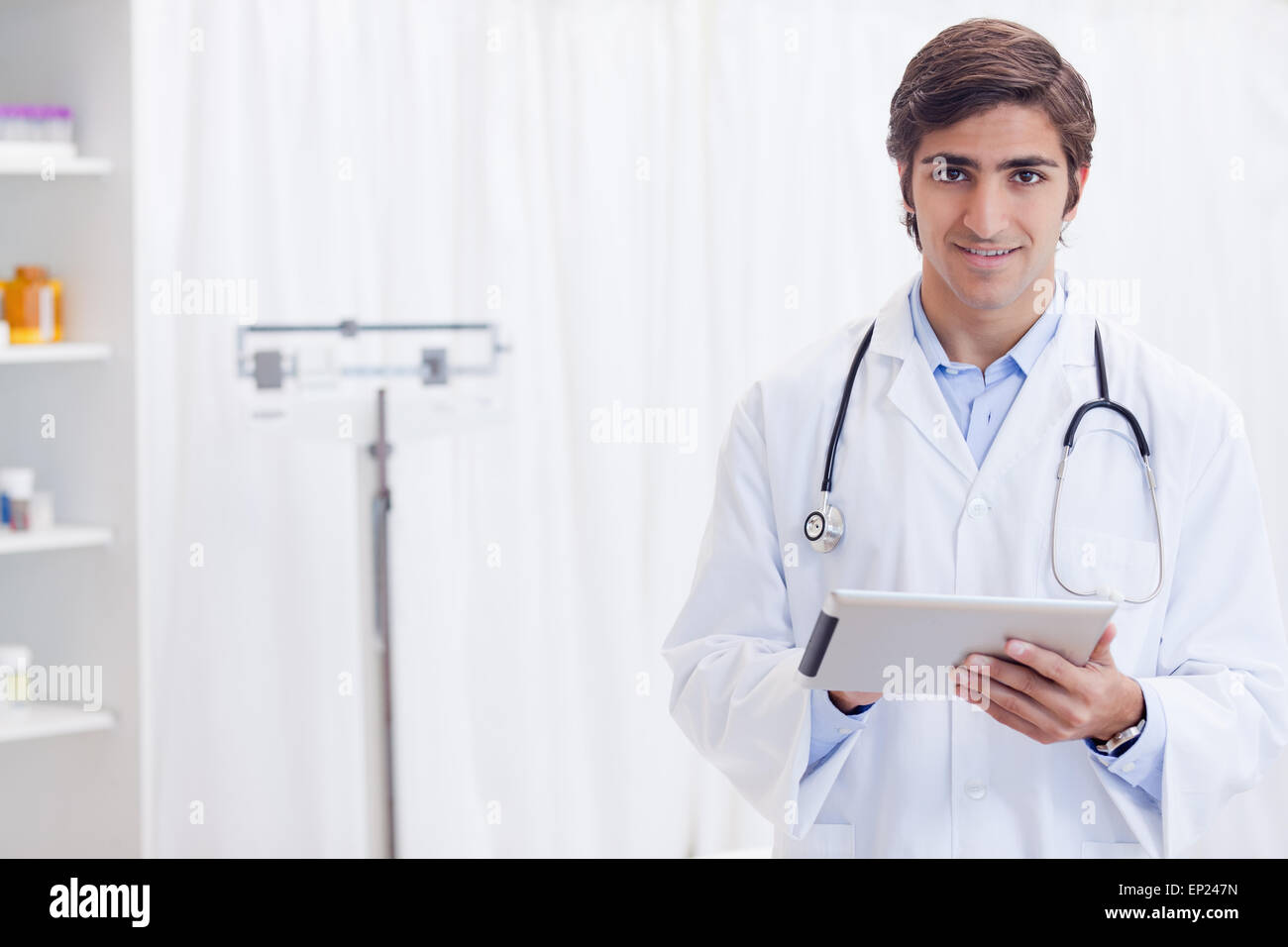 Smiling doctor with tablet Stock Photo - Alamy