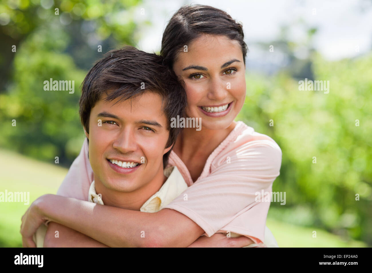 Woman smiling with her friend who is carrying her Stock Photo - Alamy