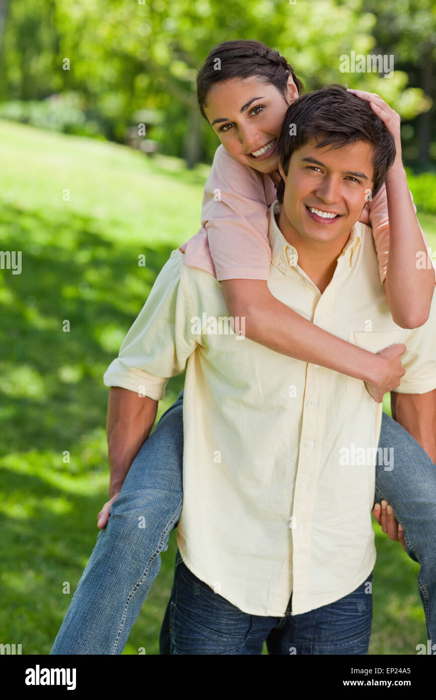 Woman with her hand on her friends head as he is carrying her Stock ...