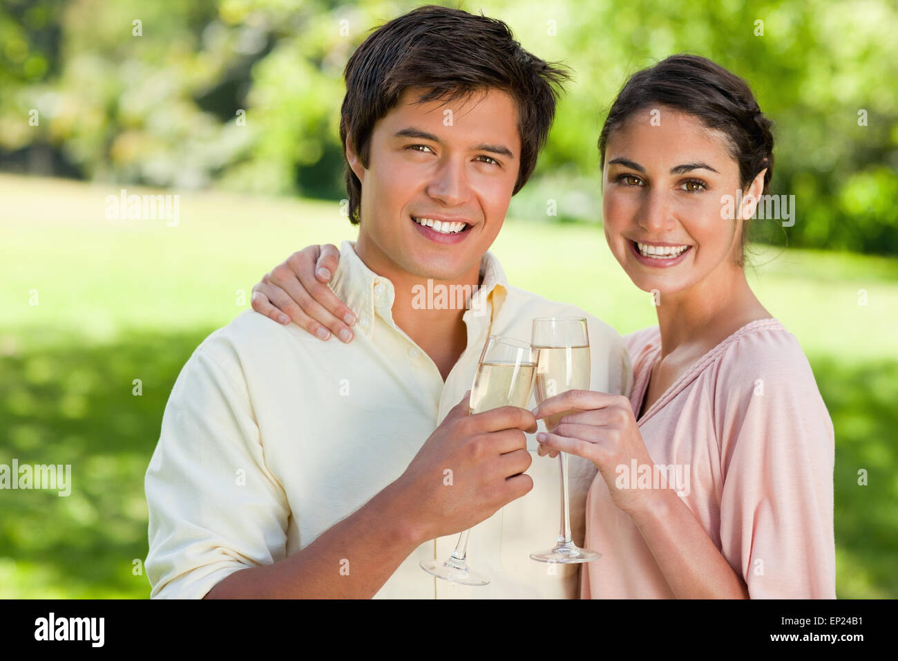 Two friends smiling while touching glasses of champagne Stock Photo - Alamy