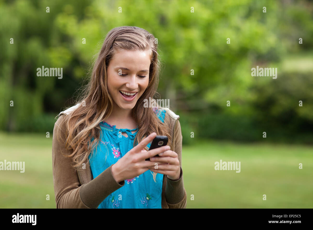 Happy teenage girl receiving a text on her mobile phone Stock Photo - Alamy