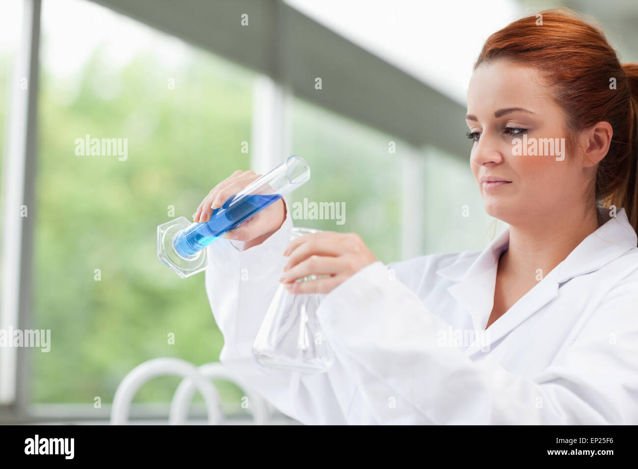 Science student pouring liquid in an Erlenmeyer flask Stock Photo - Alamy