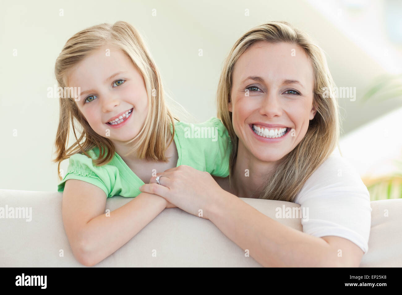 Smiling mother and daughter on the sofa Stock Photo - Alamy