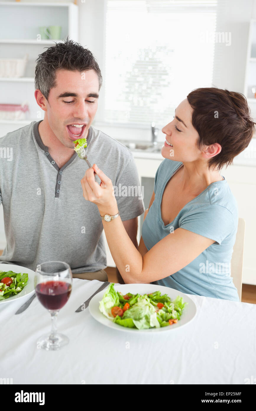Charming woman feeding her husband Stock Photo - Alamy