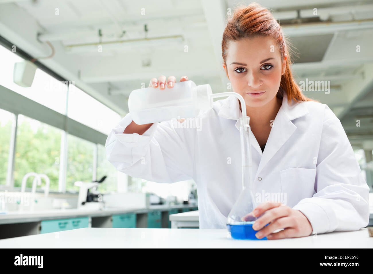Chemist pouring substance flask hi-res stock photography and images - Alamy