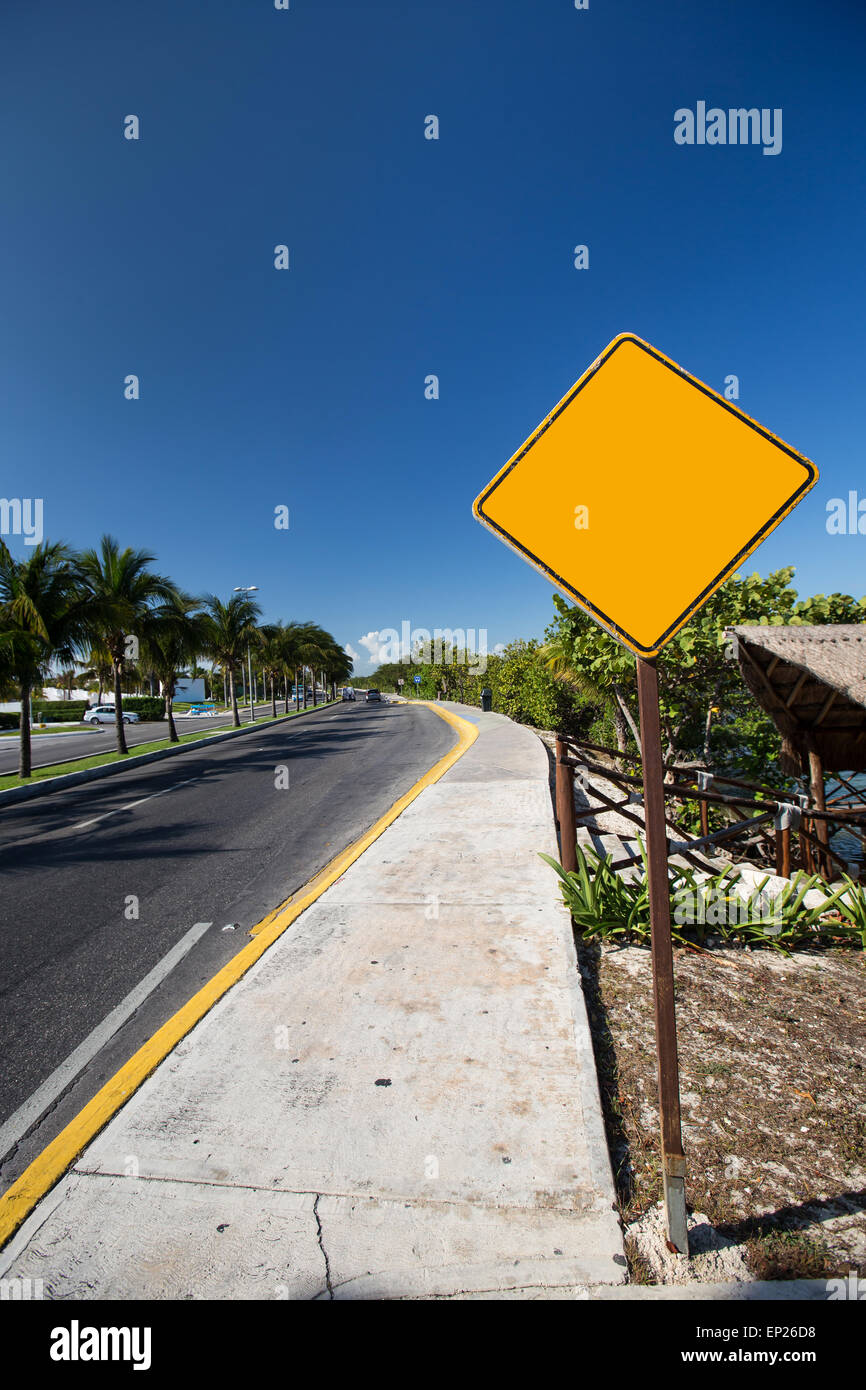 Empty yellow road sign. Tropical street Stock Photo - Alamy