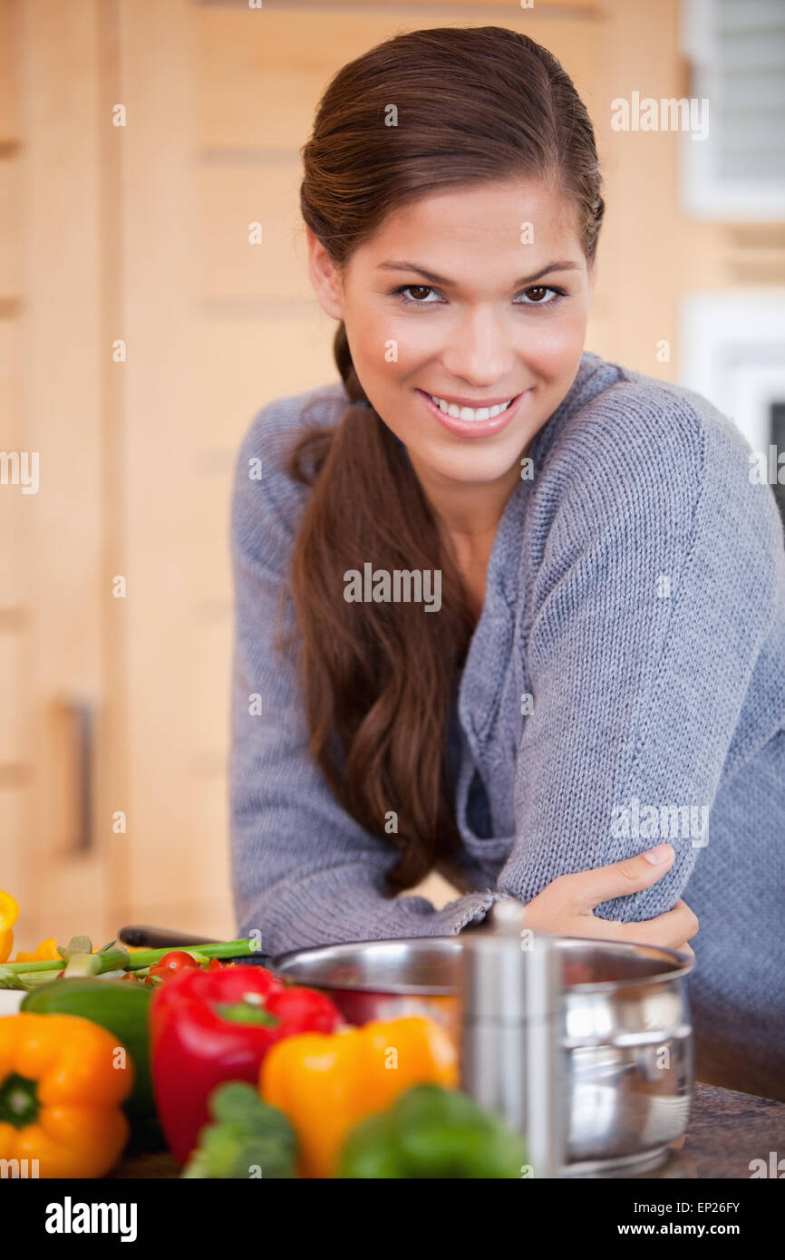 Smiling woman leaning against the kitchen counter Stock Photo - Alamy