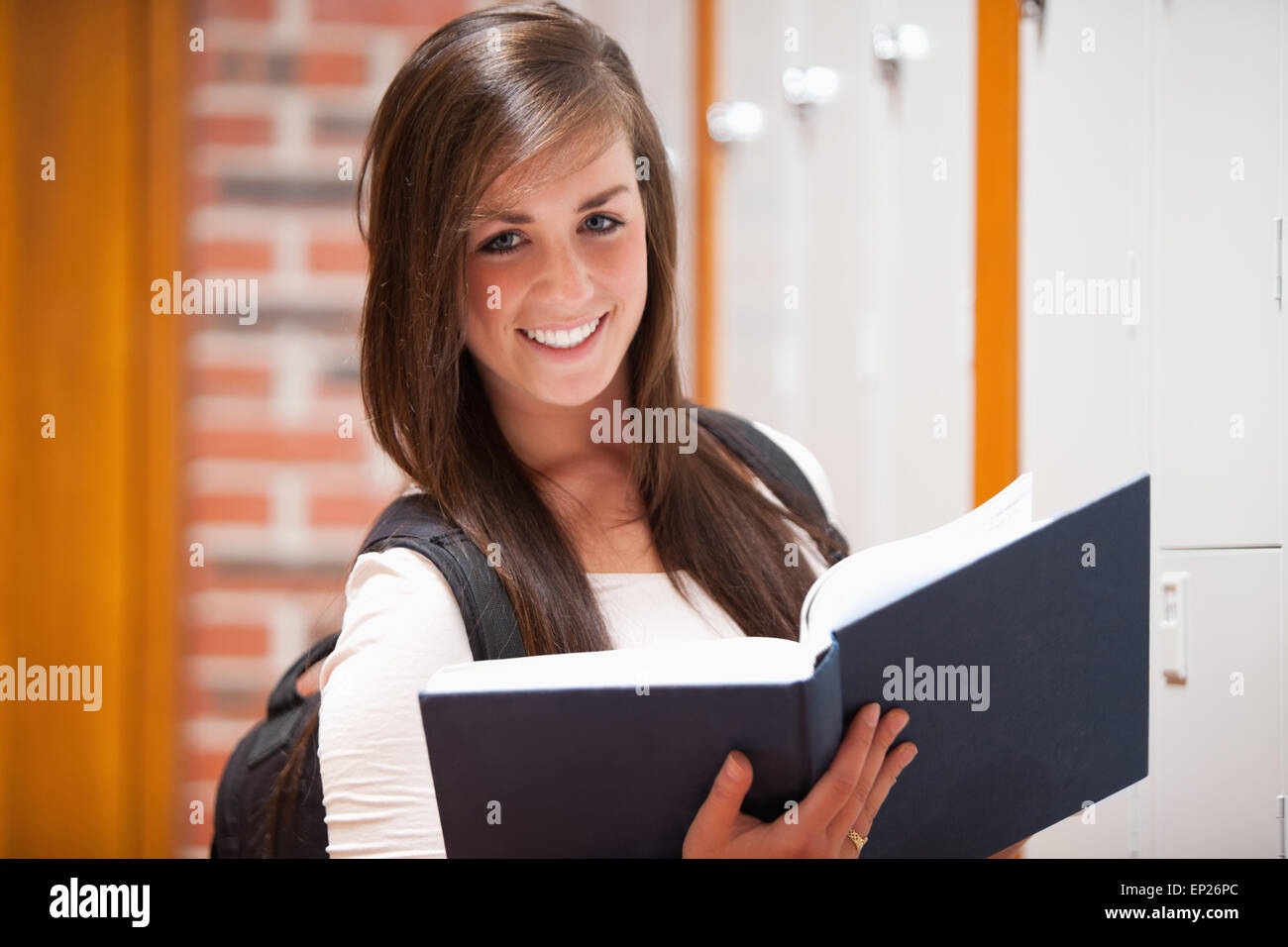 Smiling student holding a book Stock Photo - Alamy