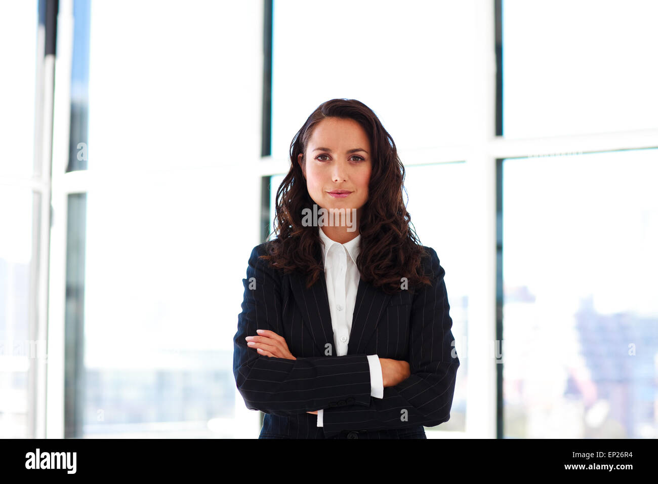 Confident businesswoman with folded arms Stock Photo - Alamy