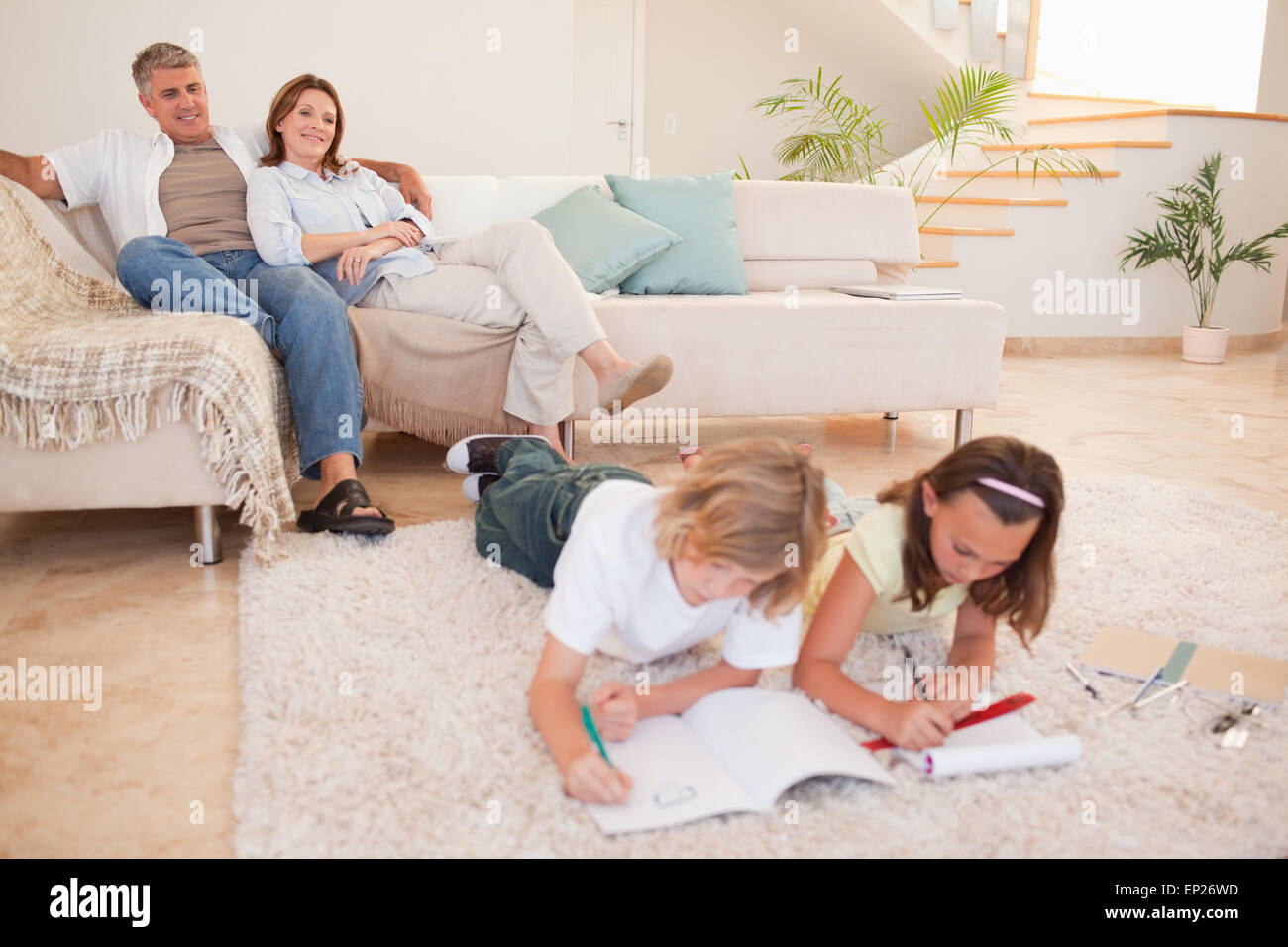 Children doing homework with parents behind them Stock Photo - Alamy
