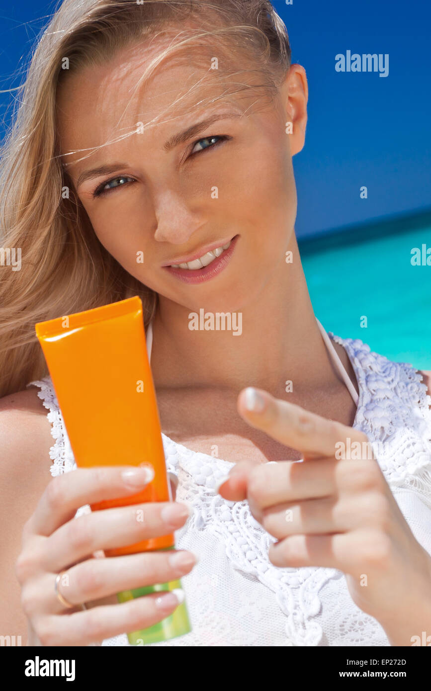 Portrait of woman holding sunscreen cream on beach, beauty concept ...