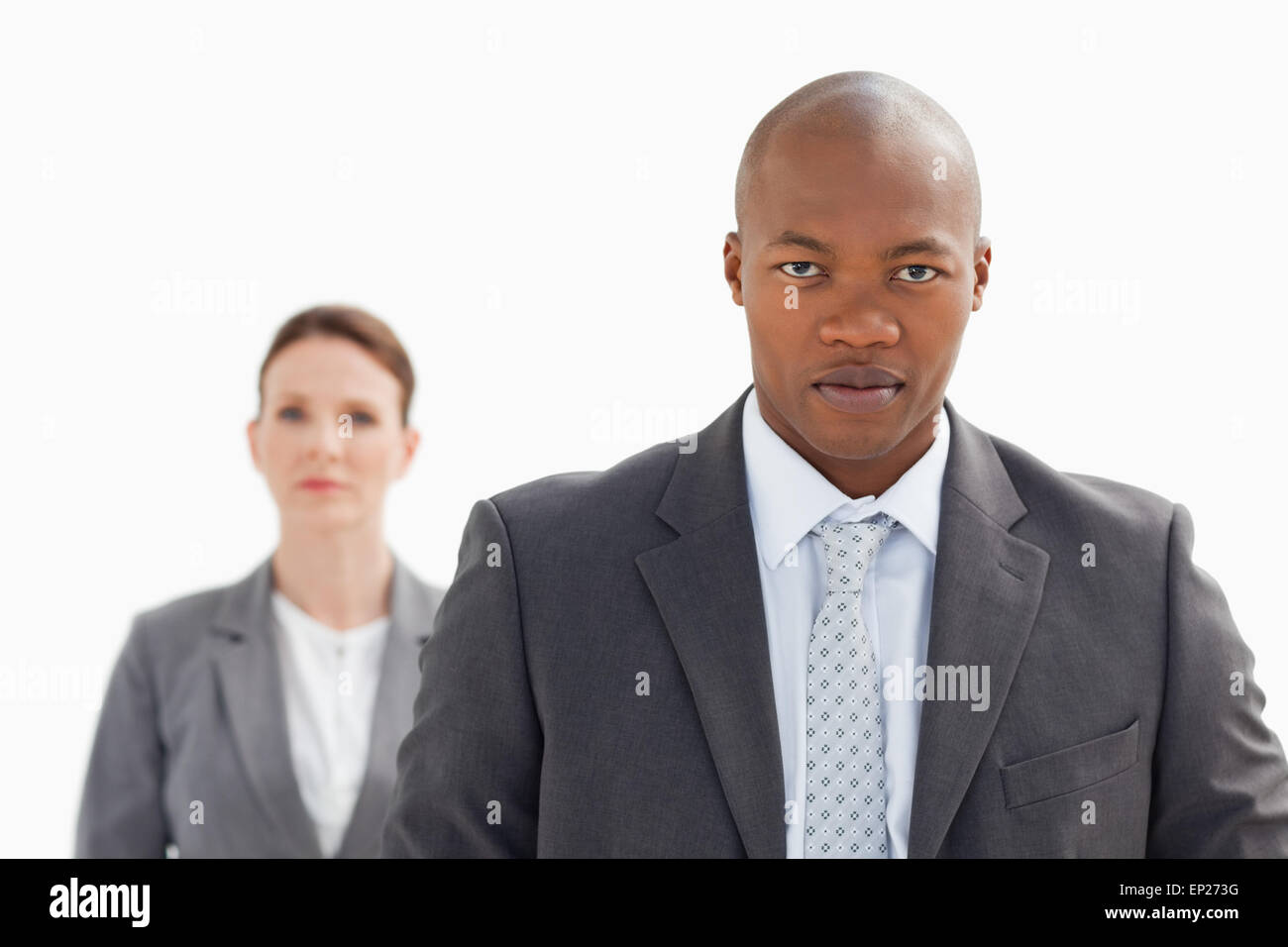 Businessman staring at camera with businesswoman behind him Stock Photo ...