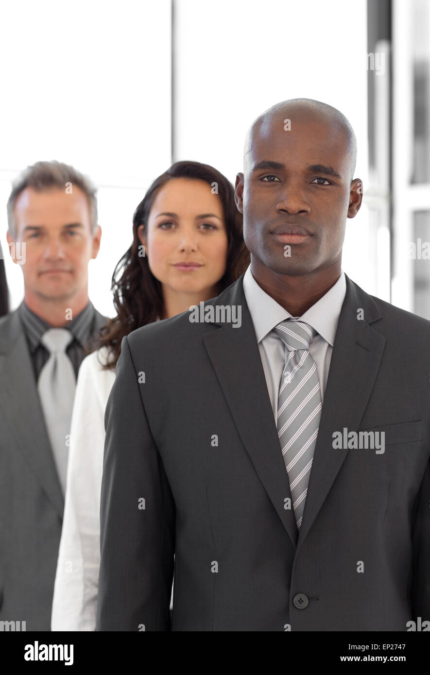 Serious ethnic business leader in front of team Stock Photo - Alamy