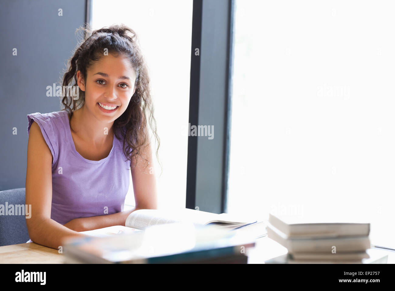 Smiling student sitting with a book Stock Photo - Alamy