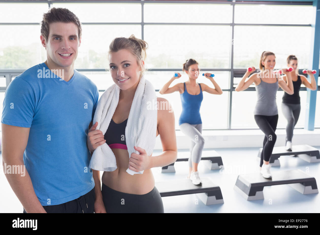 Woman and trainer smiling together in front of aerobics class Stock ...