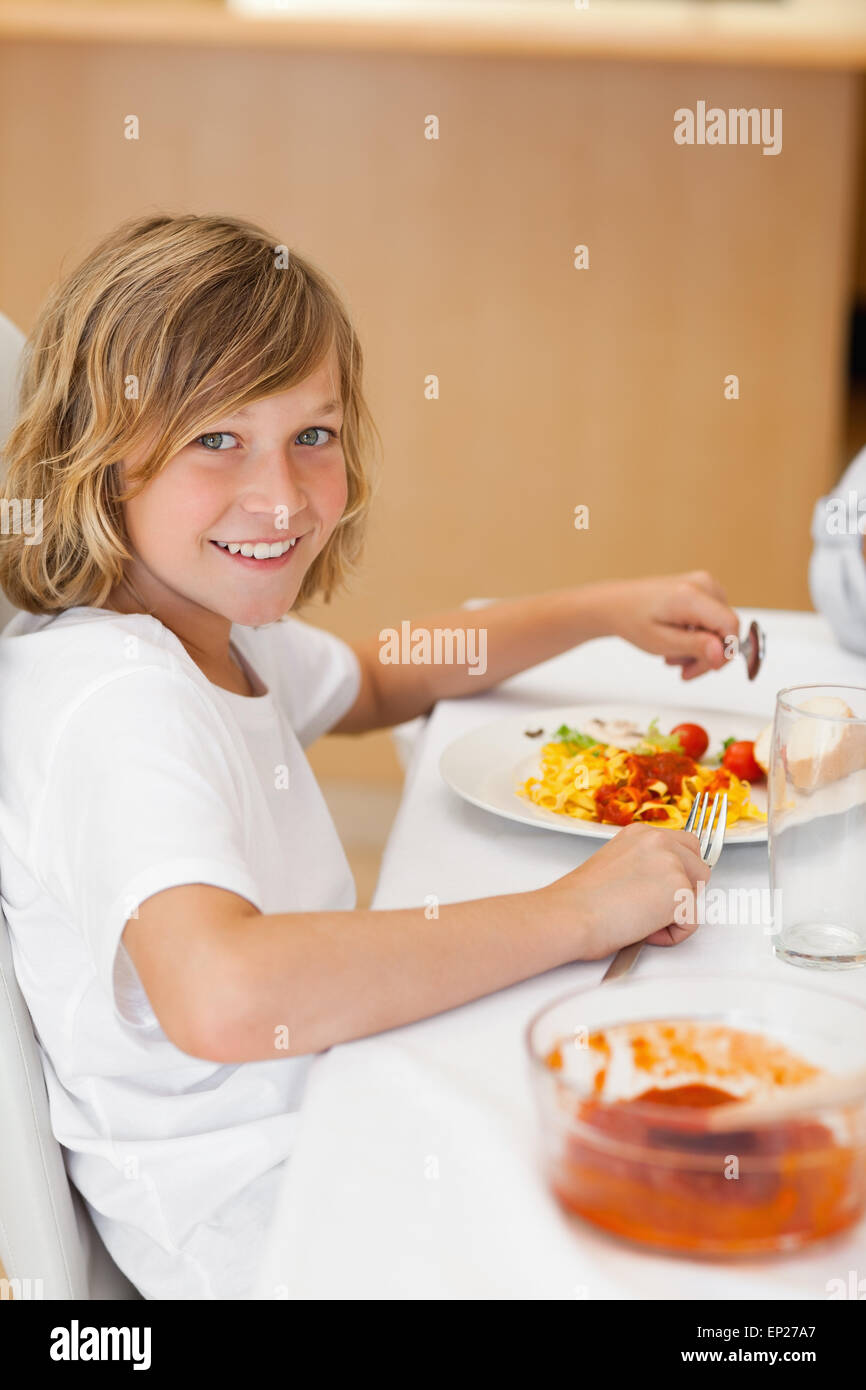 Side view of smiling boy at the dinner table Stock Photo - Alamy