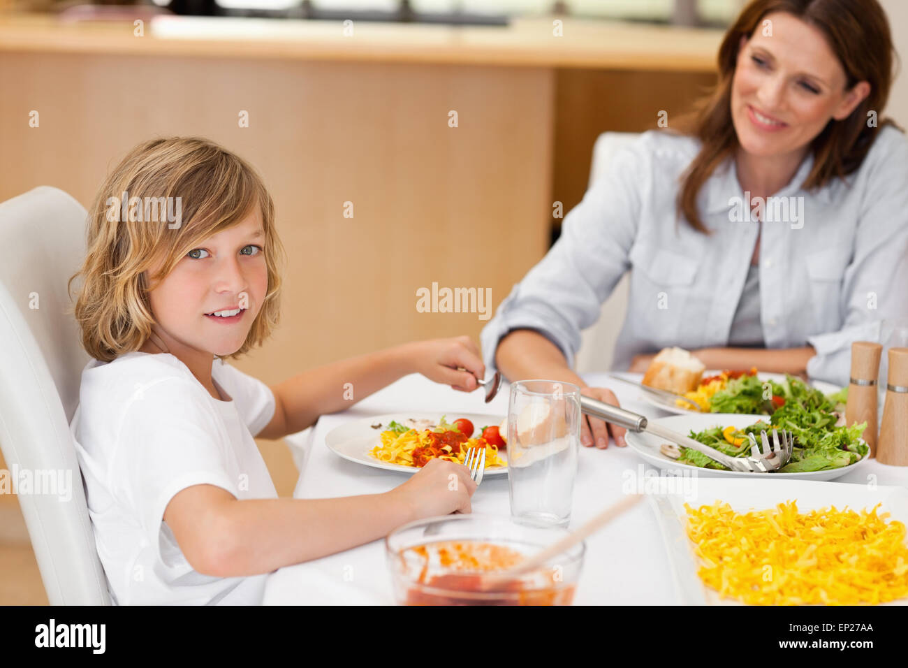 Side view of boy sitting at the dinner table Stock Photo - Alamy