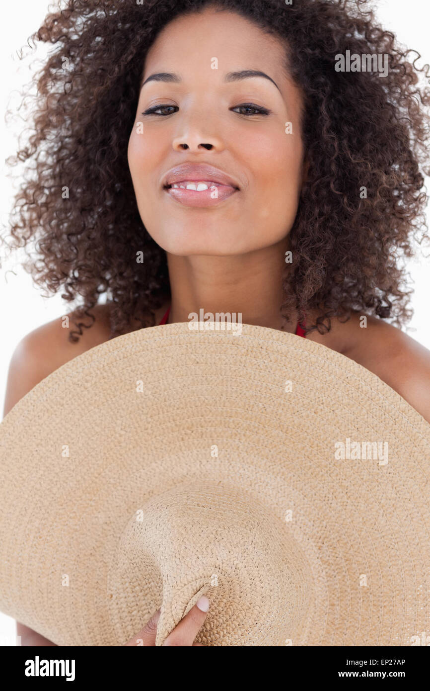 Attractive brunette woman hiding her body behind a hat Stock Photo - Alamy