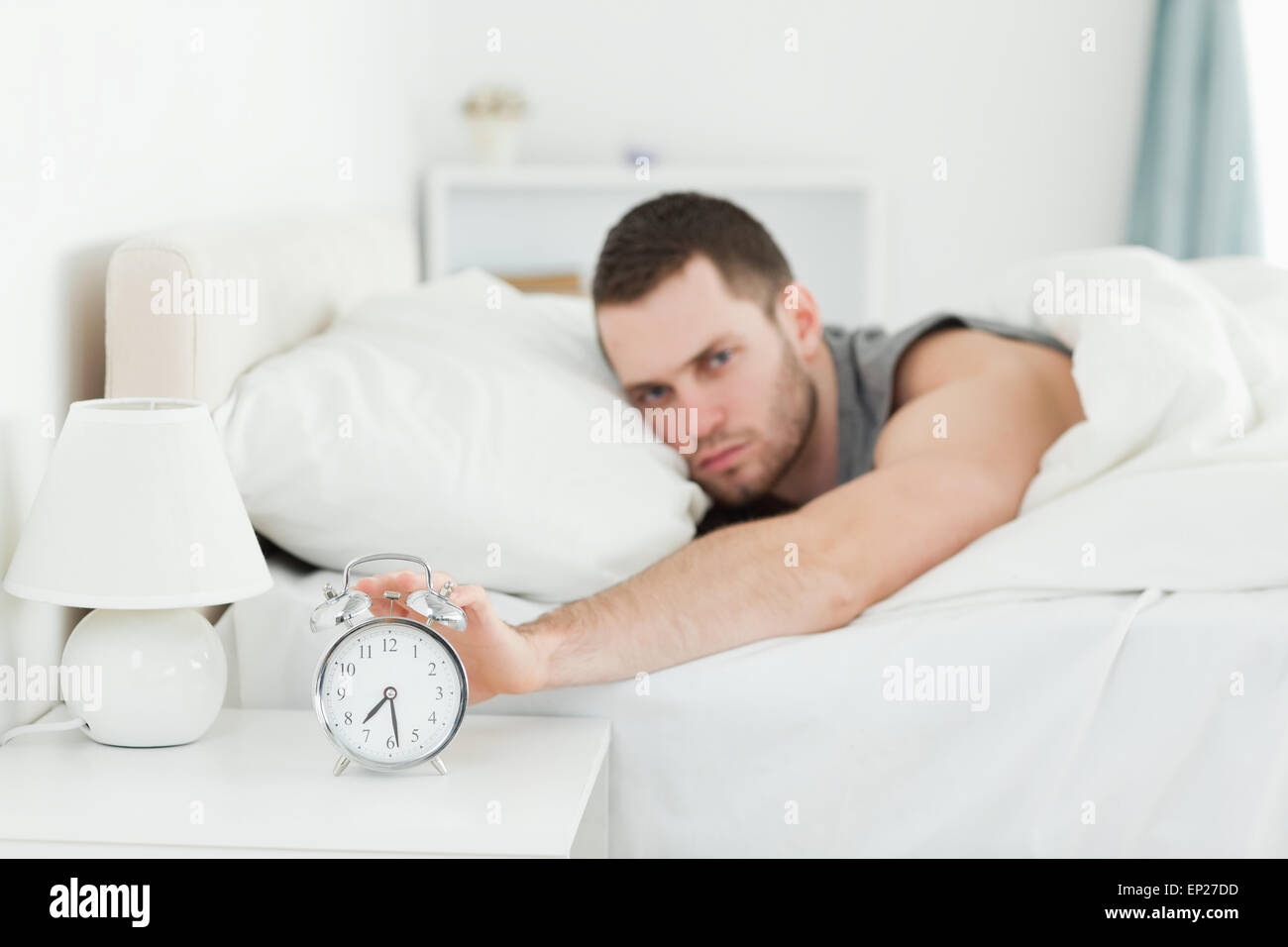 Man being awakened by an alarm clock Stock Photo - Alamy