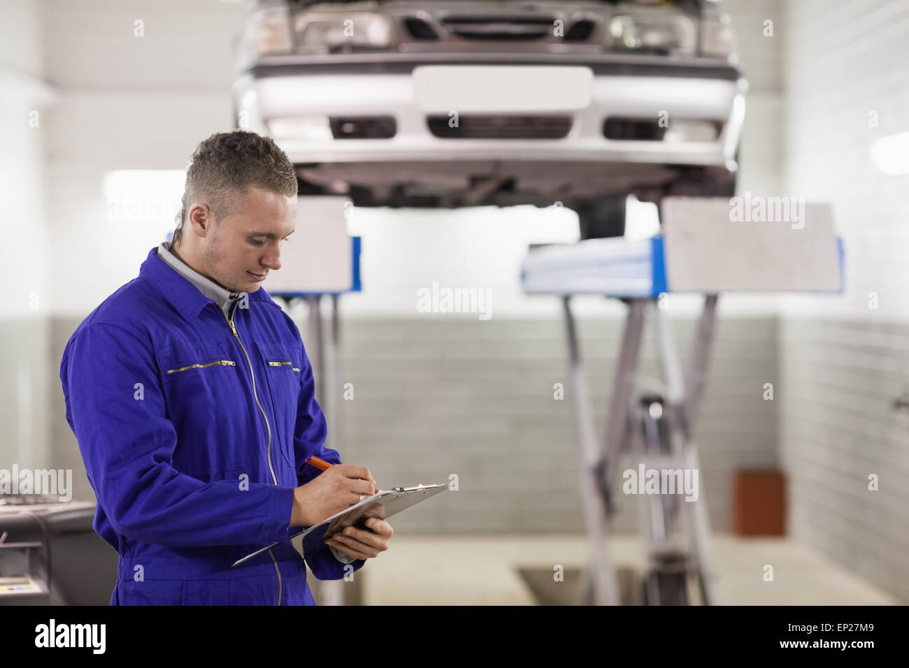 Mechanic holding a clipboard while looking at it Stock Photo - Alamy