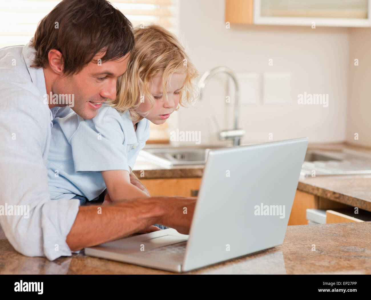 Cute boy and his father using a laptop together Stock Photo - Alamy