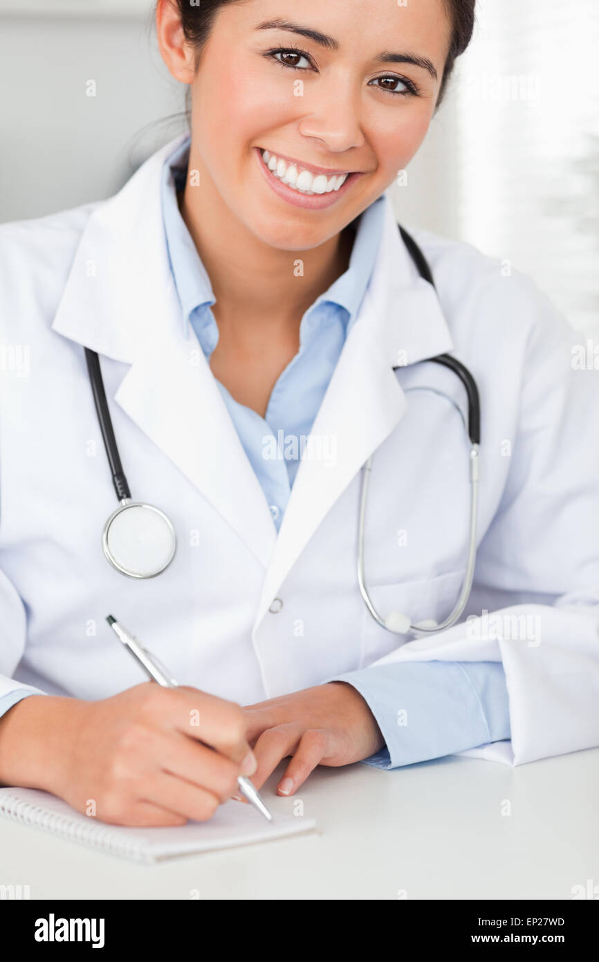Good looking female doctor writing on a scratchpad Stock Photo - Alamy
