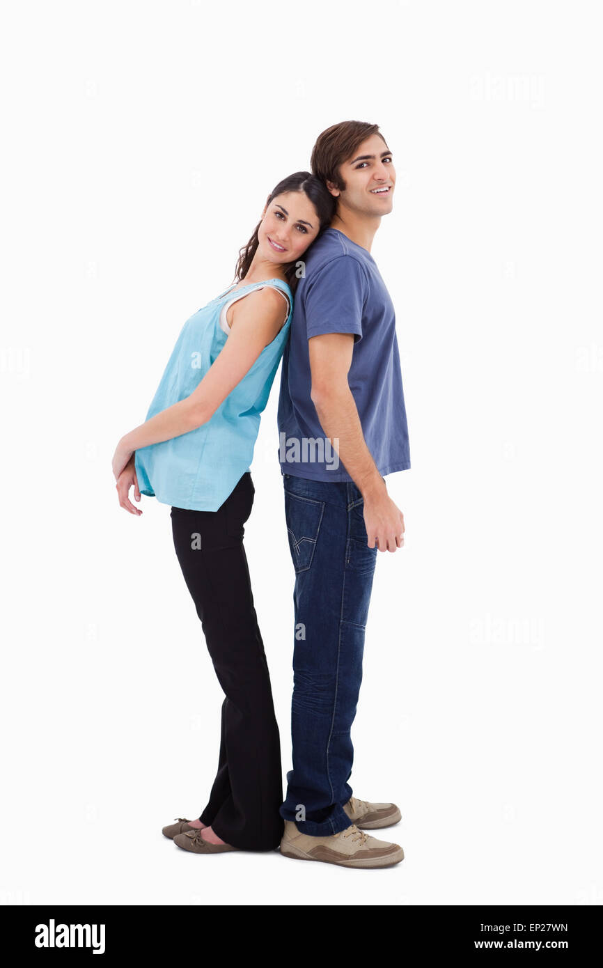 Portrait of a young couple standing back to back Stock Photo - Alamy