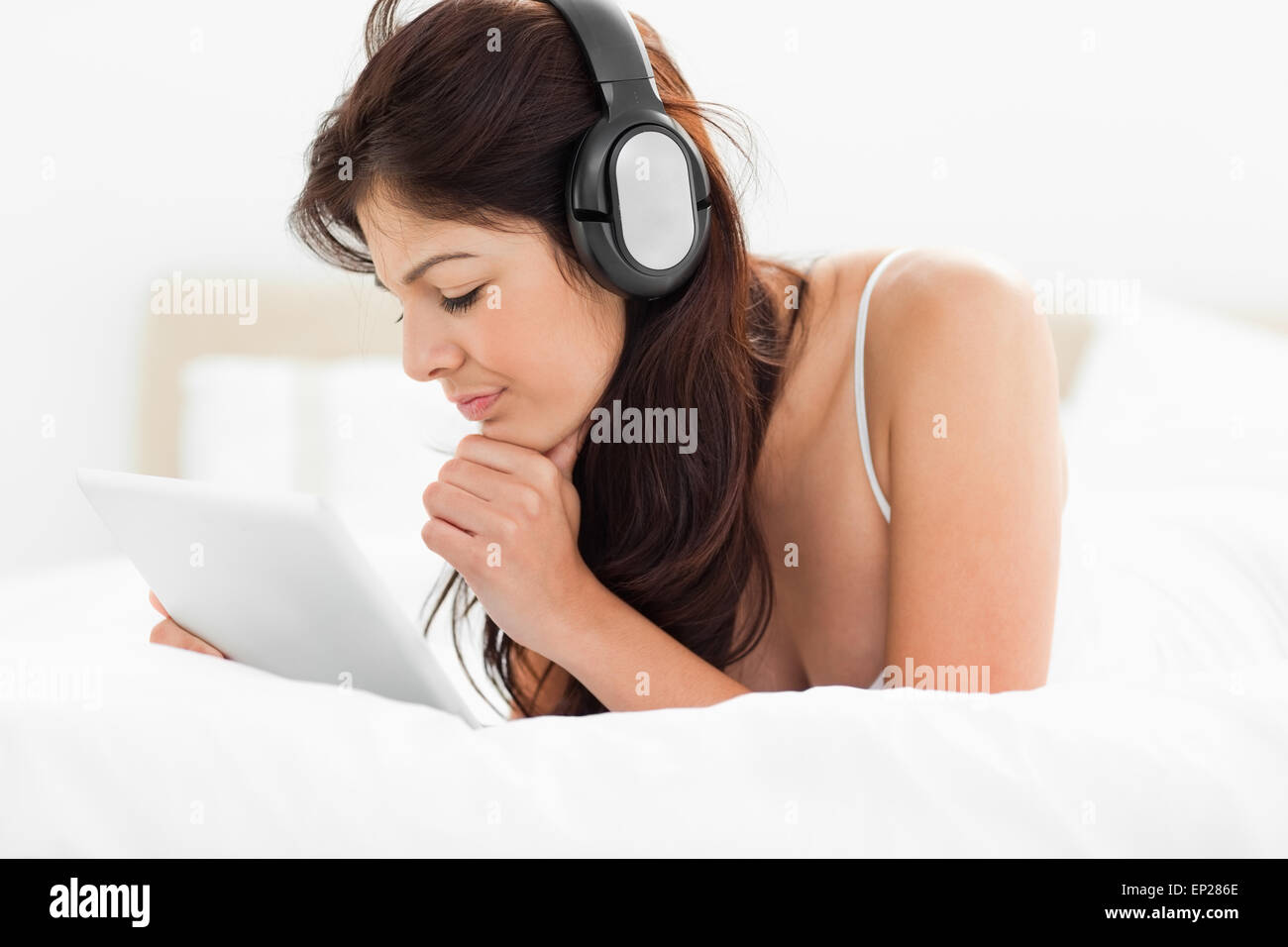 Woman with a look of concentration on her face as she uses a tablet ...