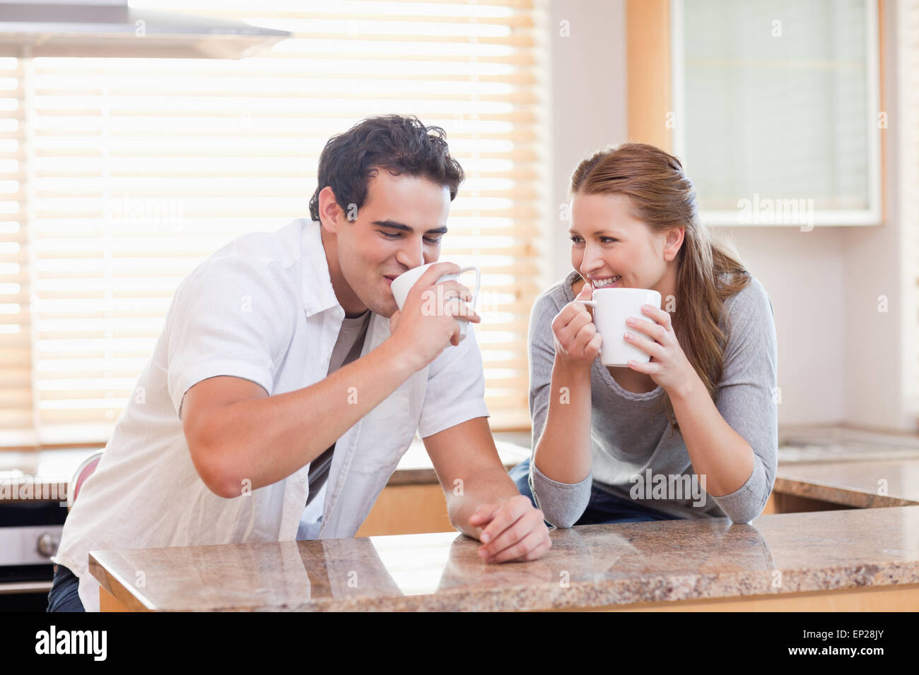 Couple drinking tea in the kitchen Stock Photo - Alamy